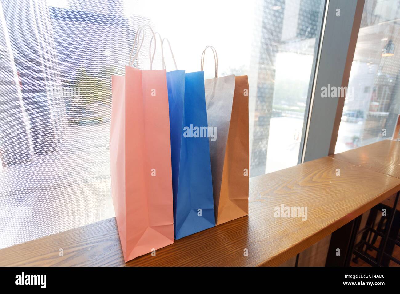 shopping bags on table near window Stock Photo - Alamy