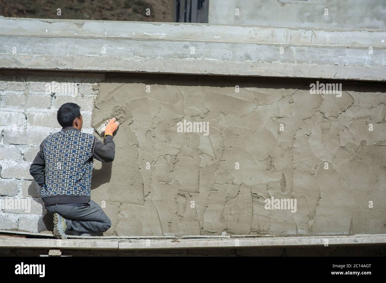 Chinese worker adding a layer of cement to a wall of bricks Stock Photo ...