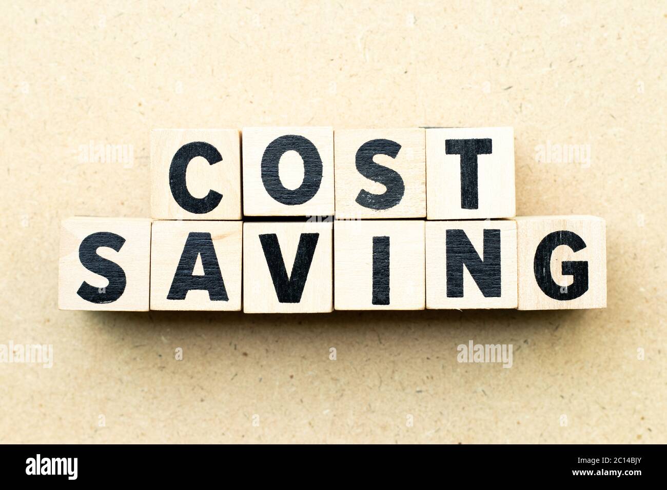 Letter block in word cost saving on wood background Stock Photo - Alamy