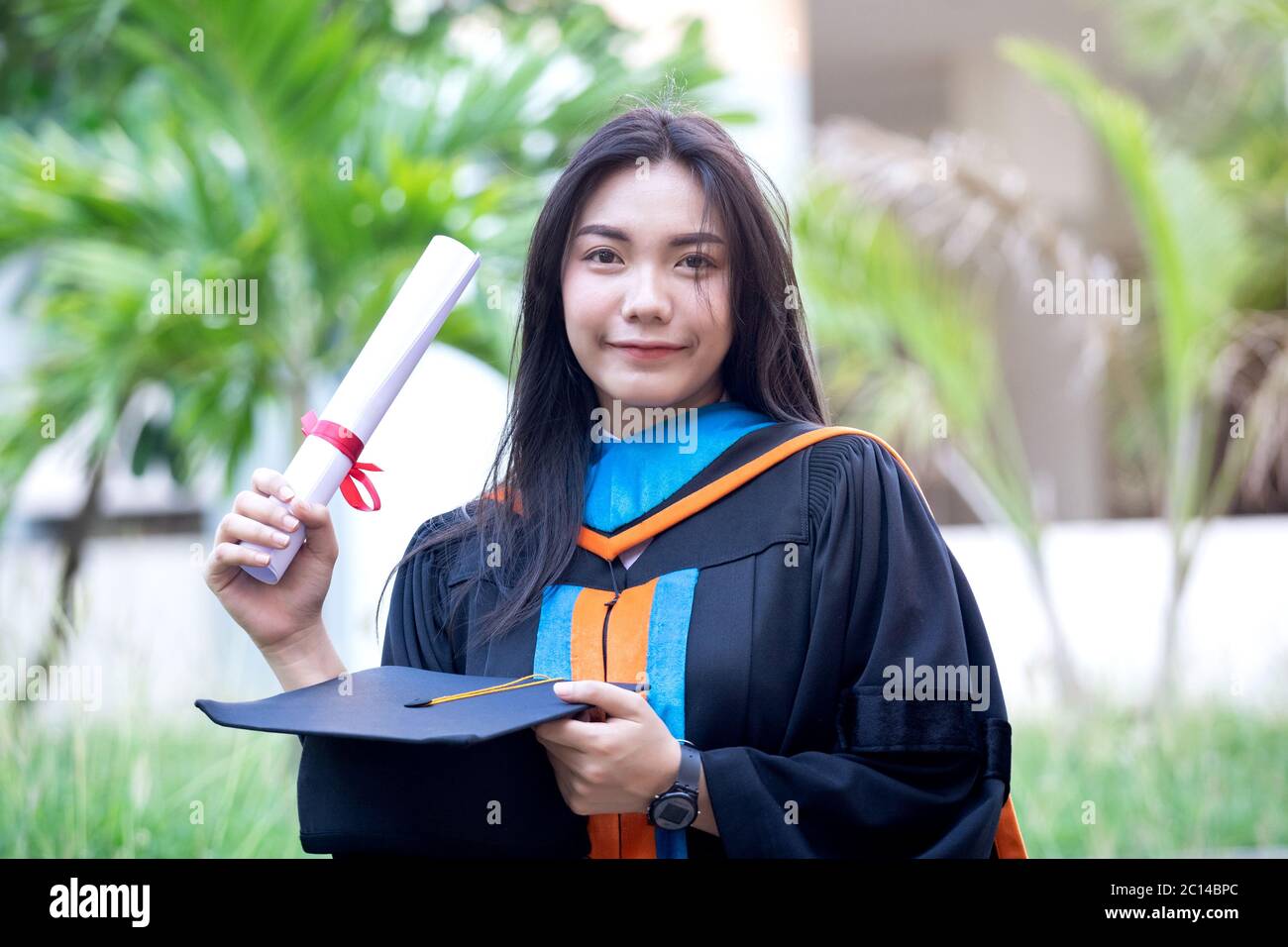 Portrait of happy and excited of young Asian female university graduate ...
