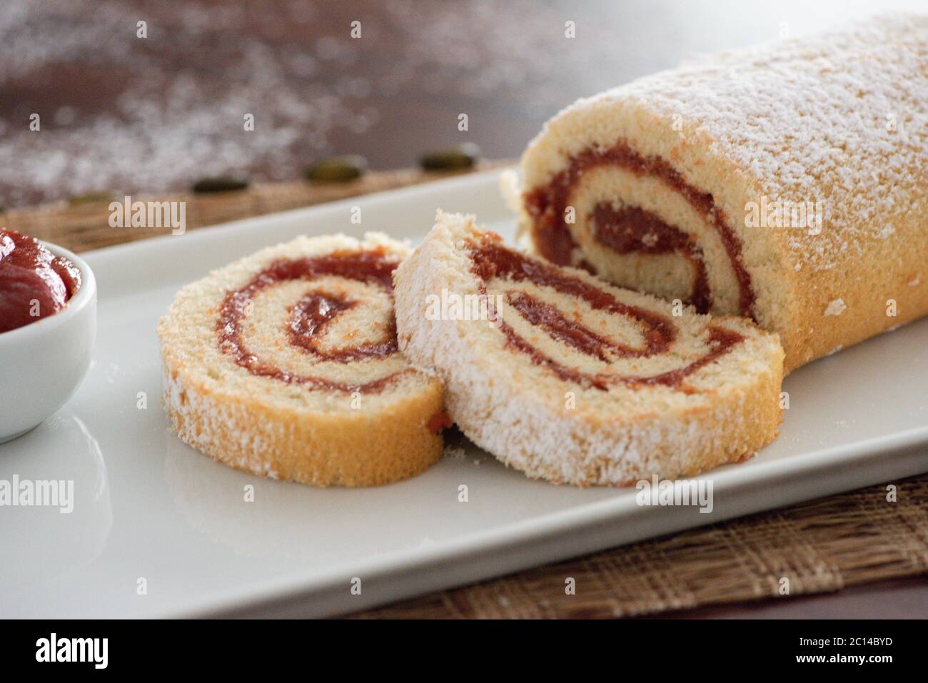 delicious roll cake with guava cream jelly and sugar sliced on white ...