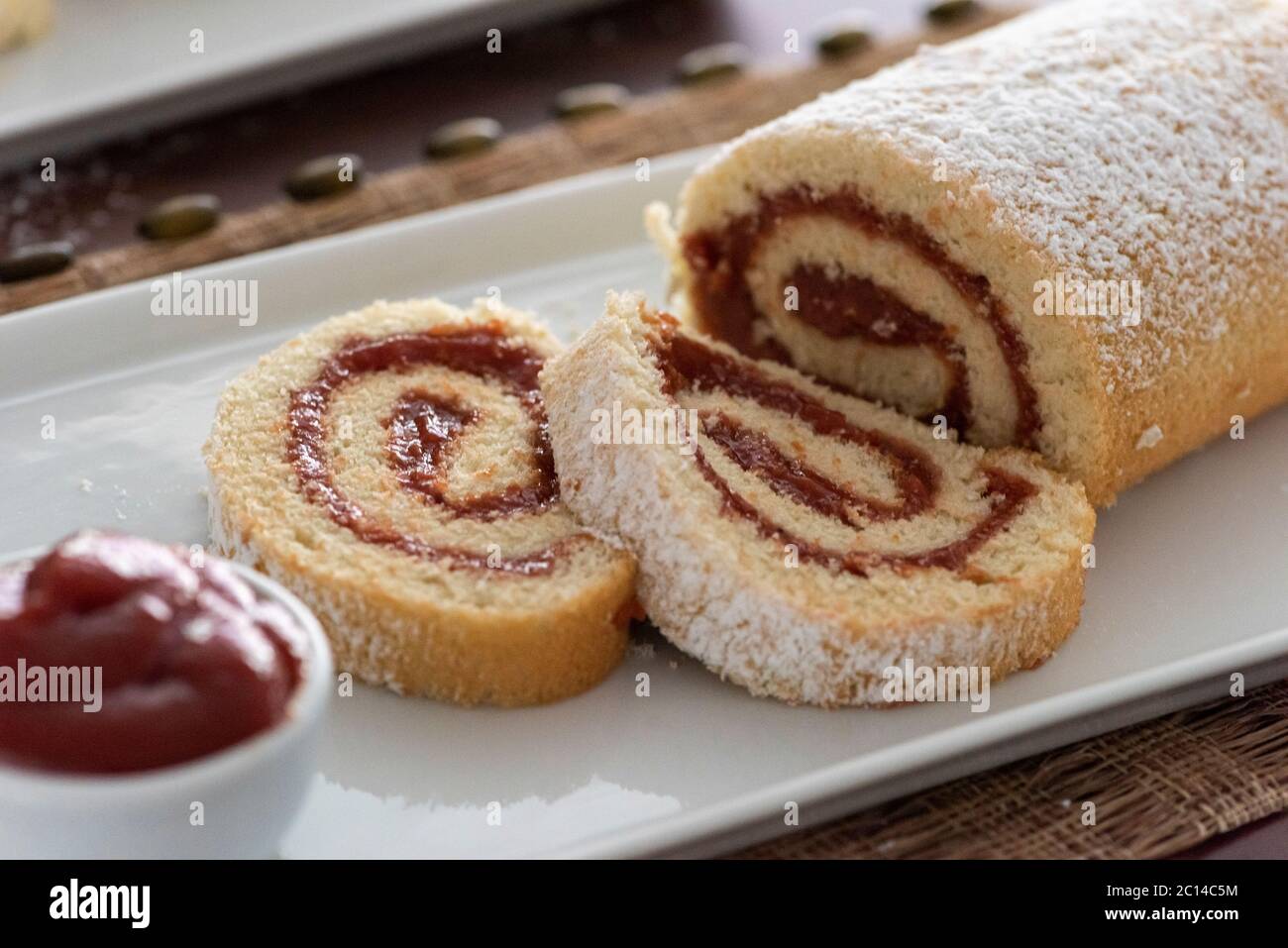 delicious roll cake with guava cream jelly and sugar sliced on white ...