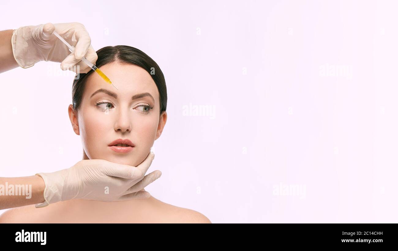 Face needle injection. Young woman cosmetology procedure. Doctor gloves ...