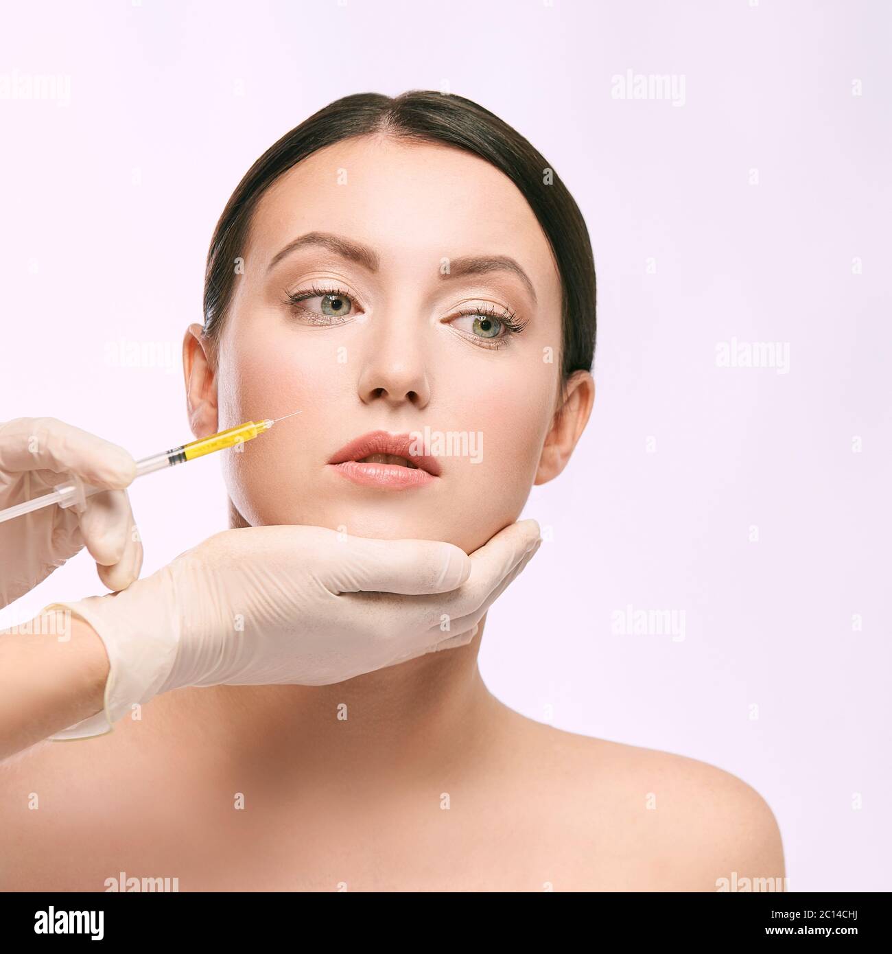 Face needle injection. Young woman cosmetology procedure. Doctor gloves ...