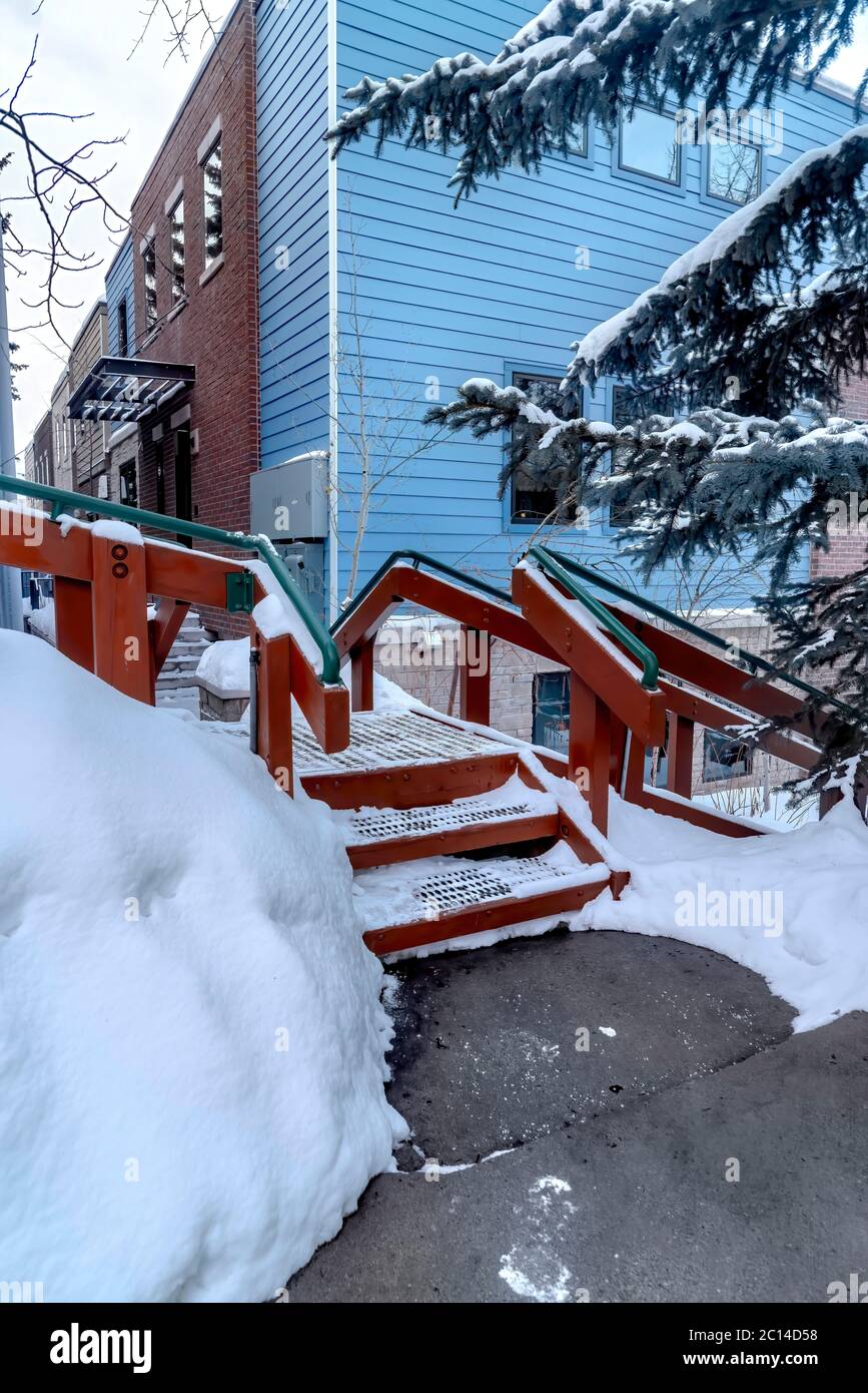 Oudoor stairs with grate metal treads and green handrails against a ...