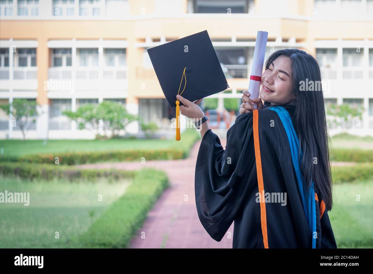 Portrait of happy and excited of young Asian female university graduate ...