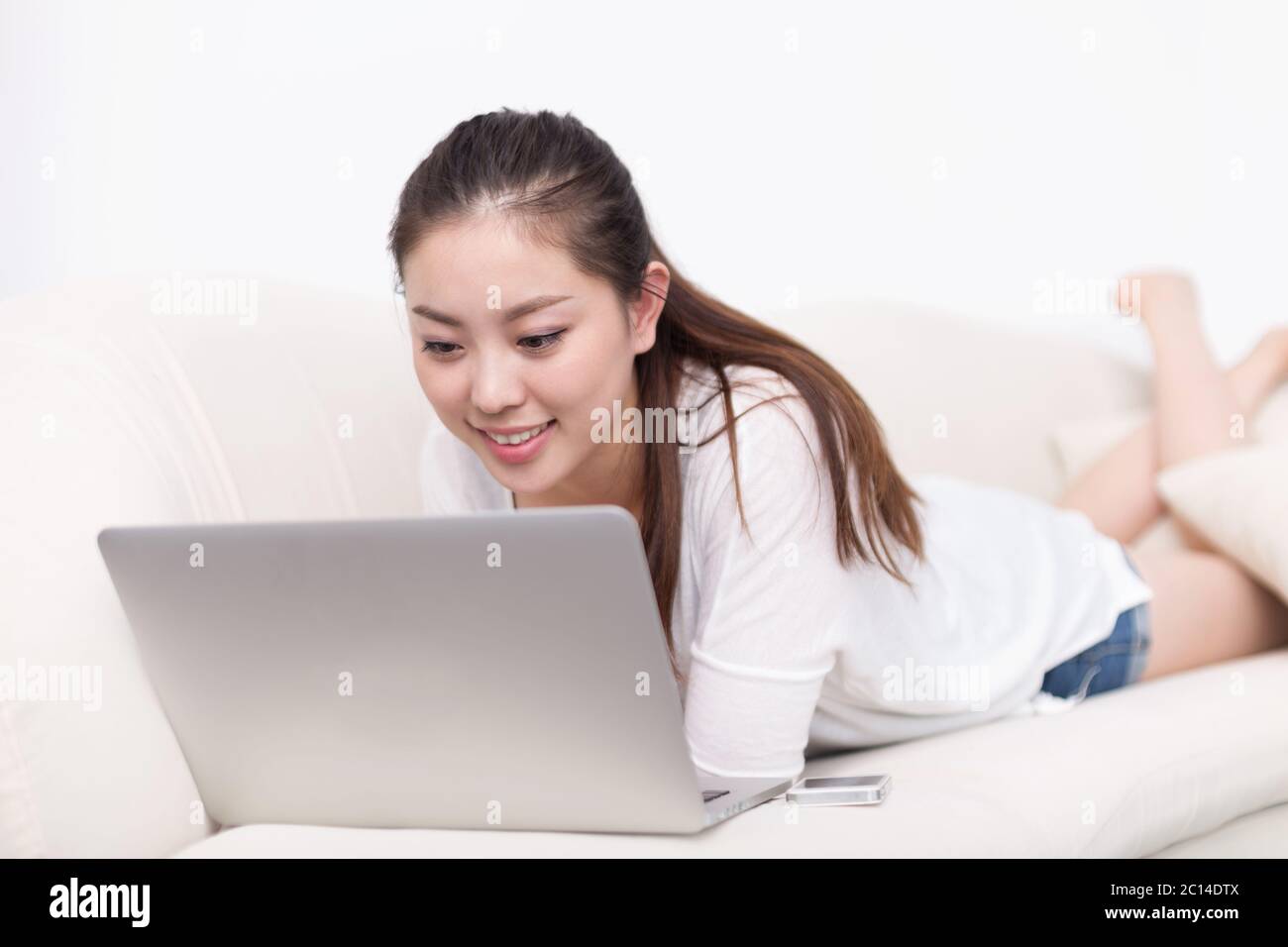 Woman using laptop on bed hi-res stock photography and images - Alamy