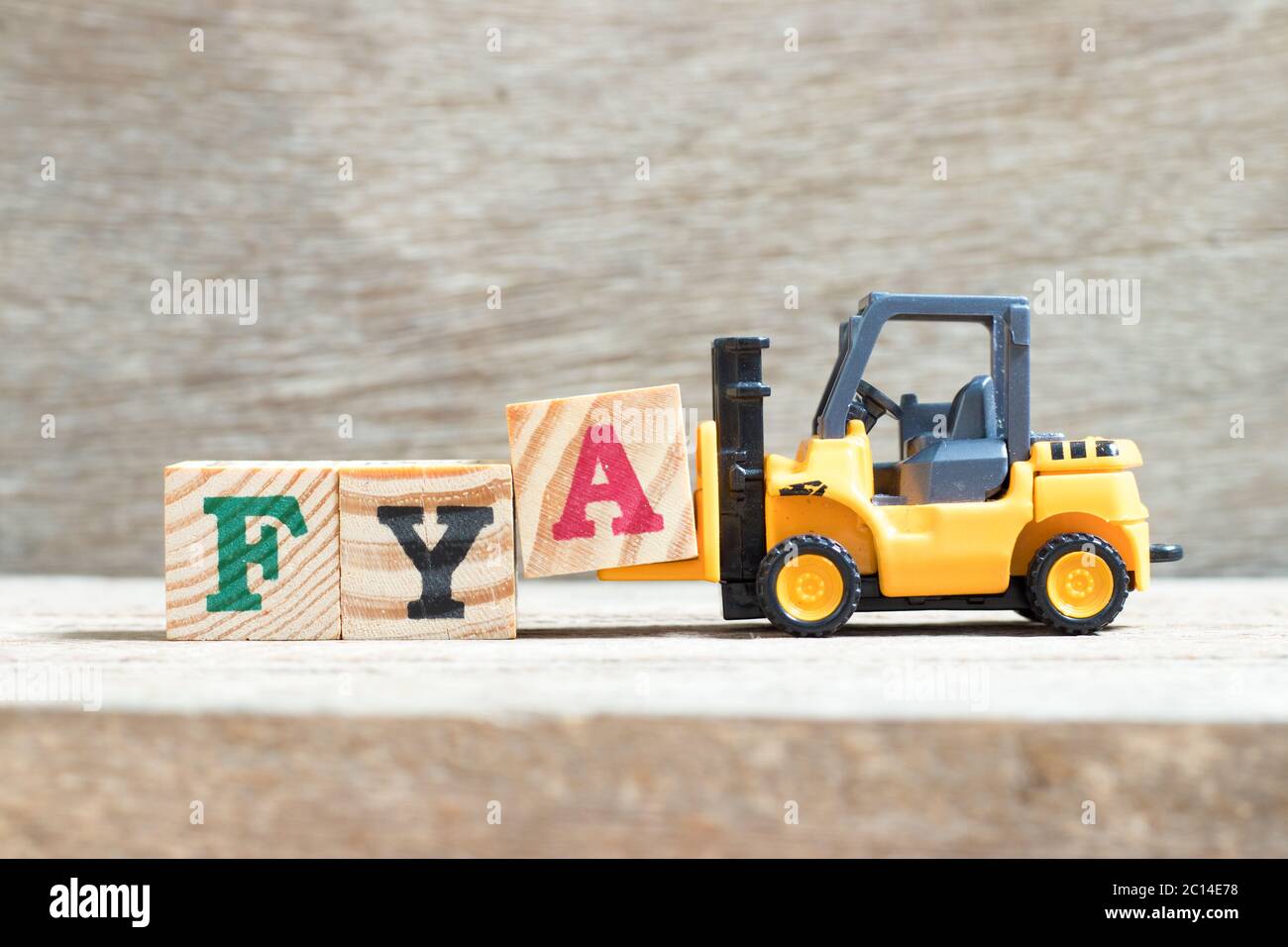Toy forklift hold letter block A to complete word FYA (Abbreviation of ...