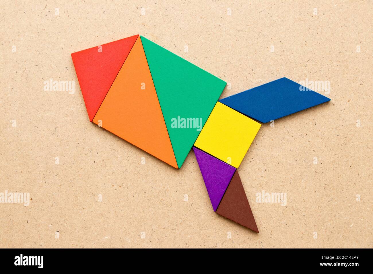 Color tangram puzzle in rocket or missile shape on wood background ...