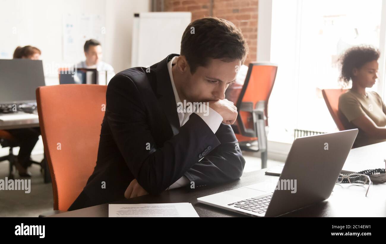 Serious businessman employee using laptop, working on difficult project ...