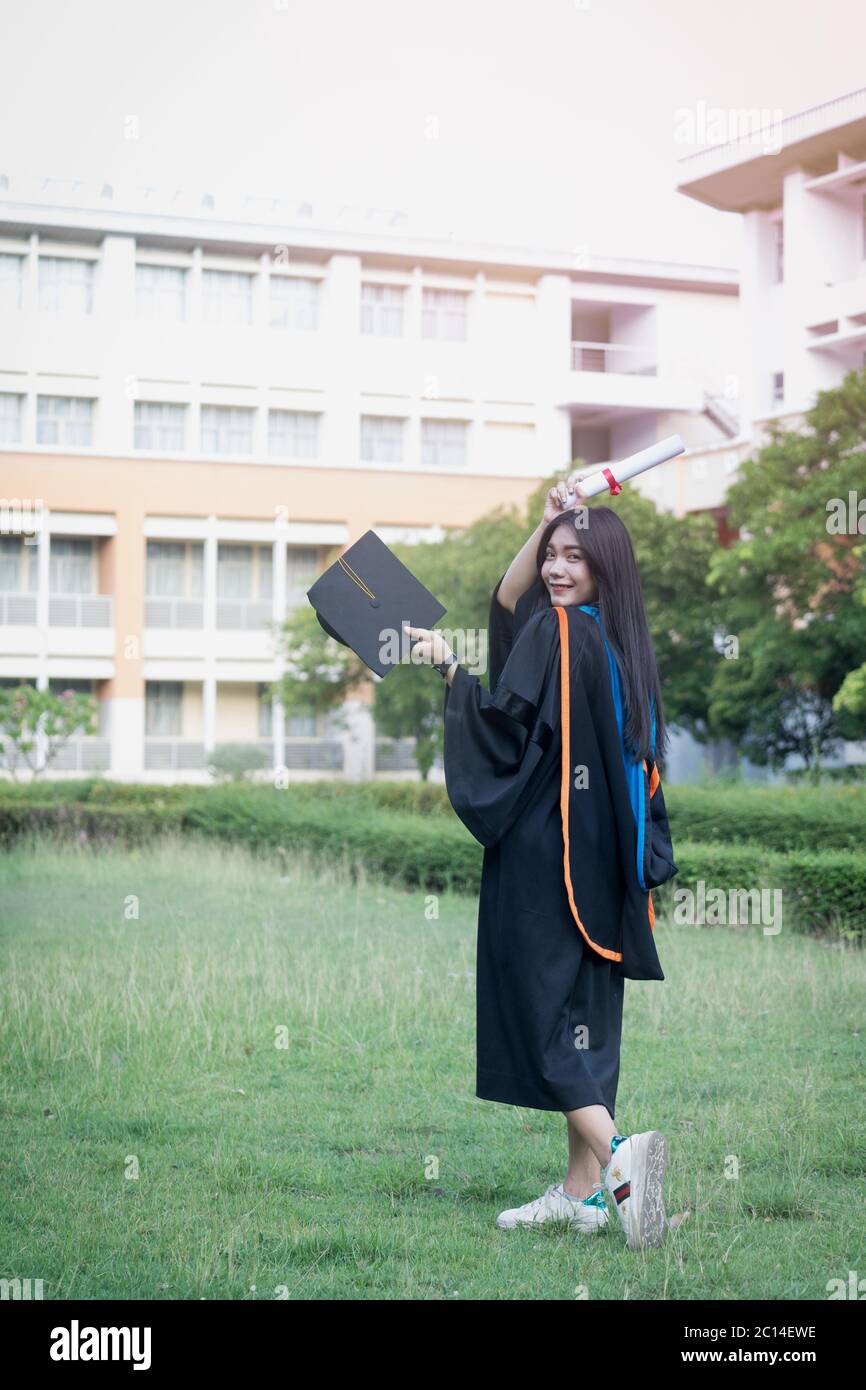 Portrait of happy and excited of young Asian female university graduate ...