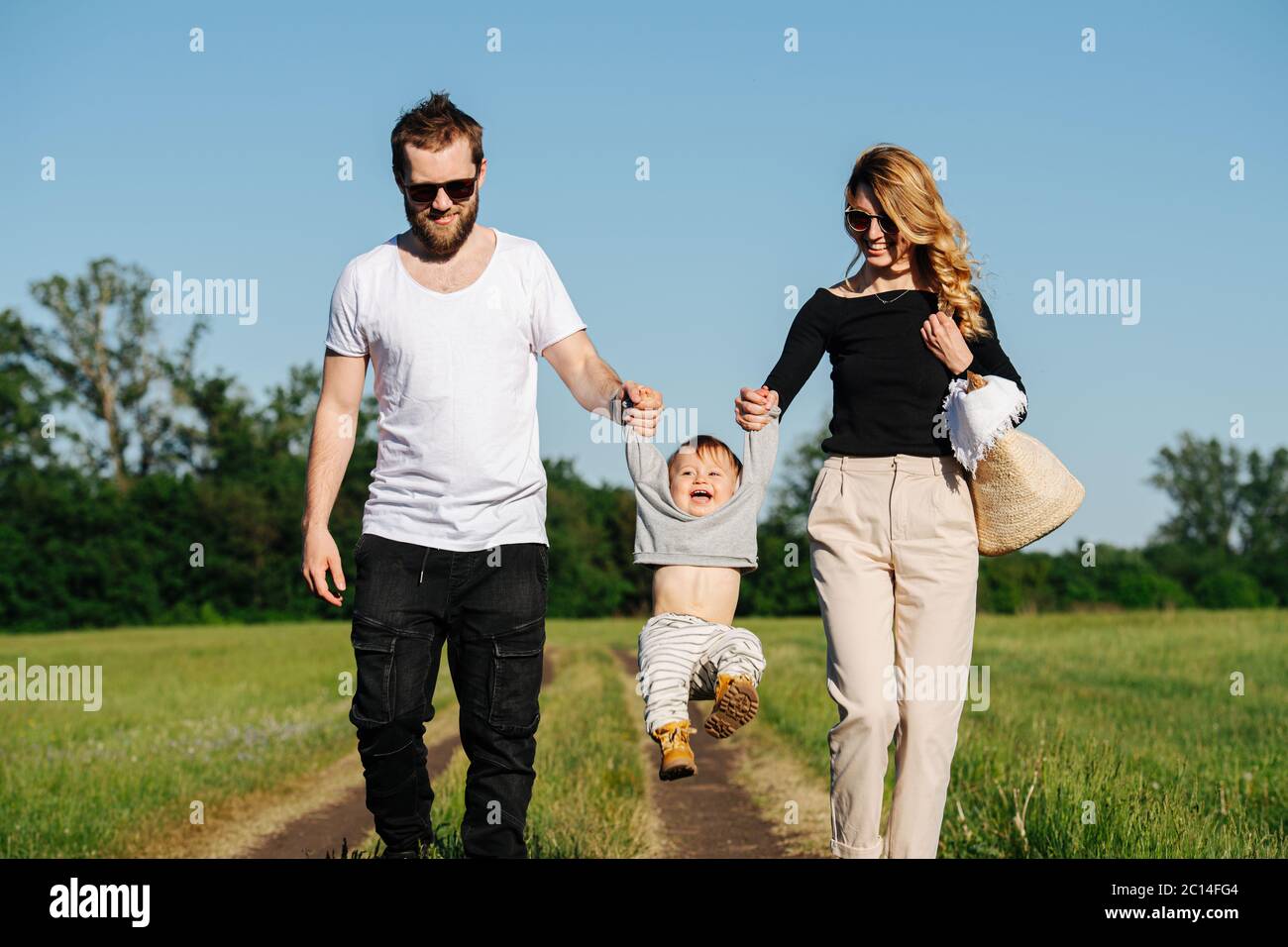 Emotional baby hanging in the air, his parents entertaining him Stock ...