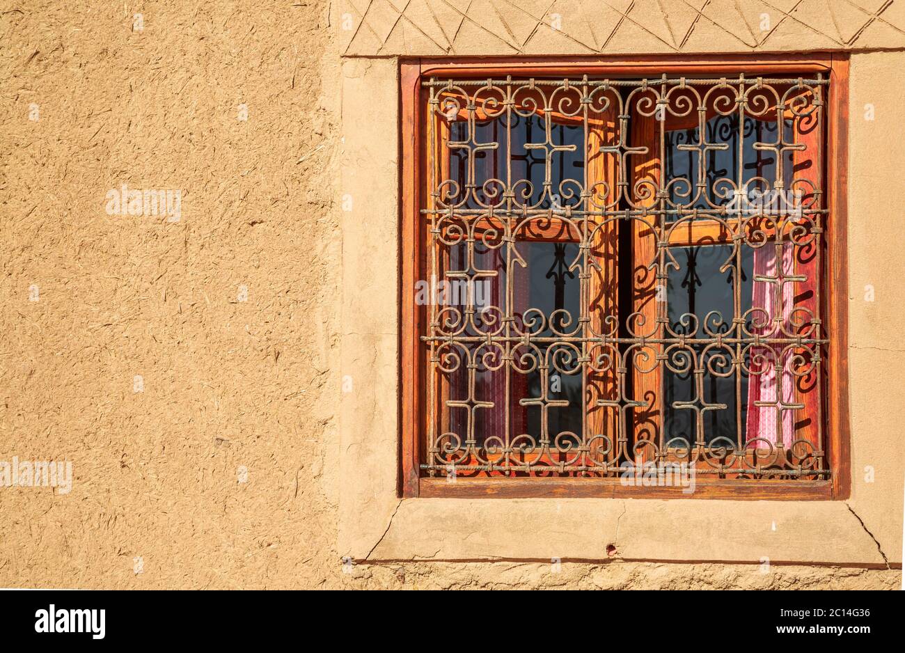 Rammed earth wall with traditional wrought iron window Stock Photo - Alamy