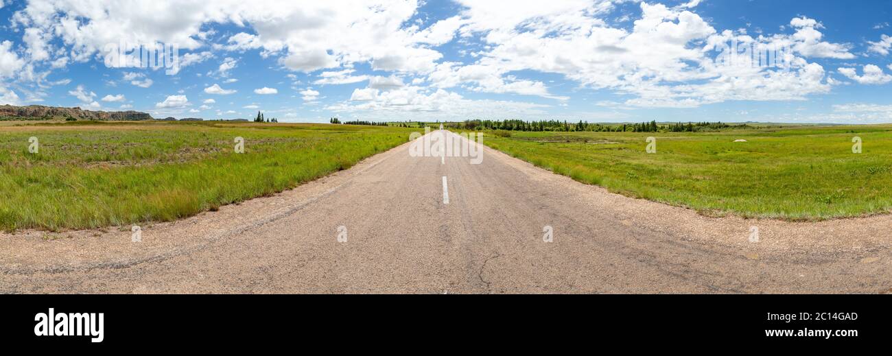 The straight asphalt road with meadows on both sides Stock Photo - Alamy