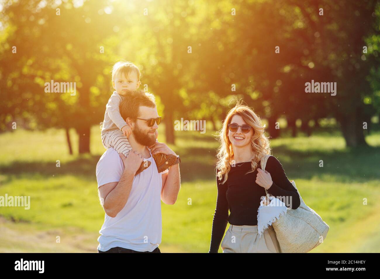 Happy family walking in countryside during beautiful sunny day outside ...