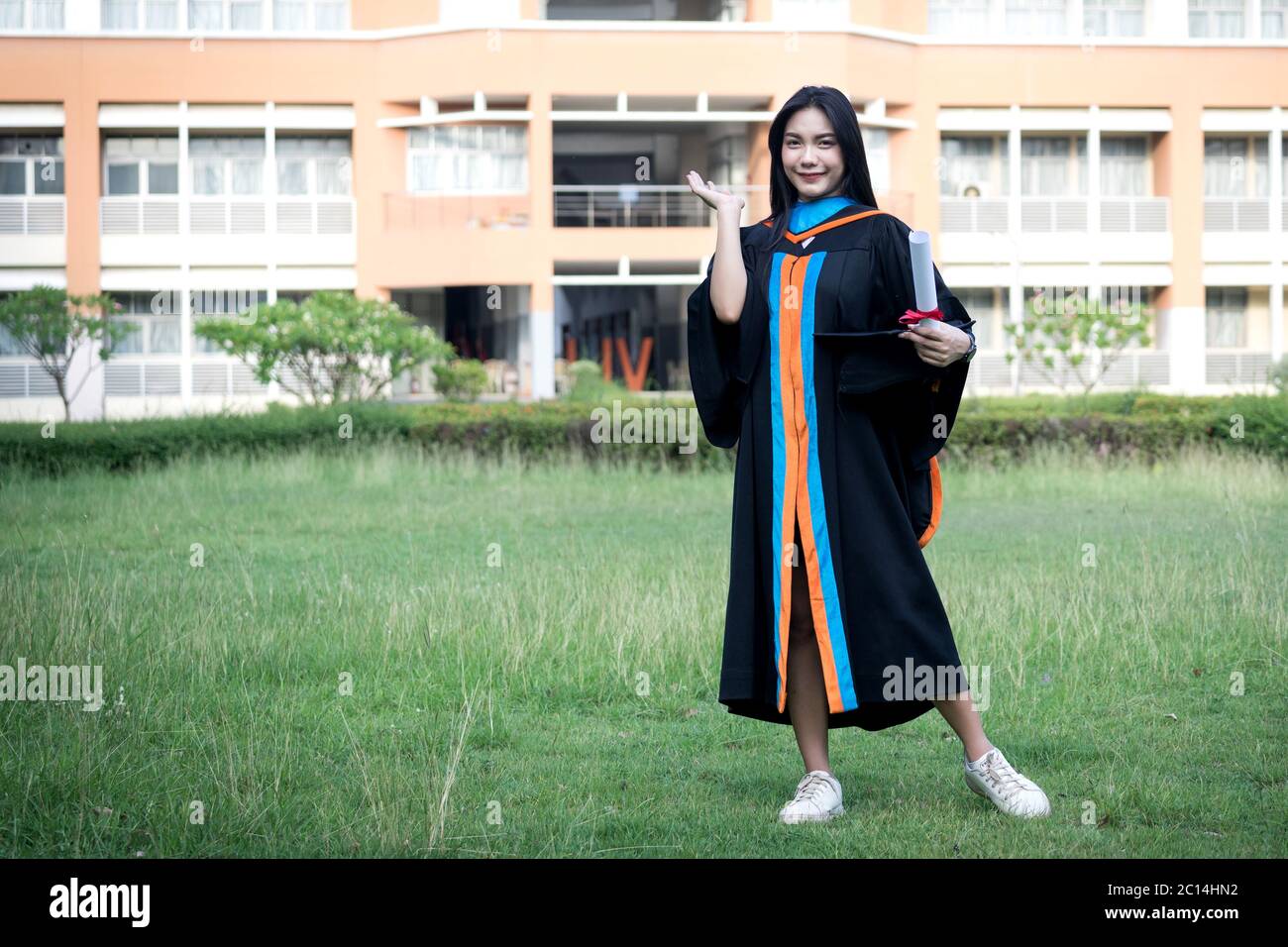 Portrait of happy and excited of young Asian female university graduate ...