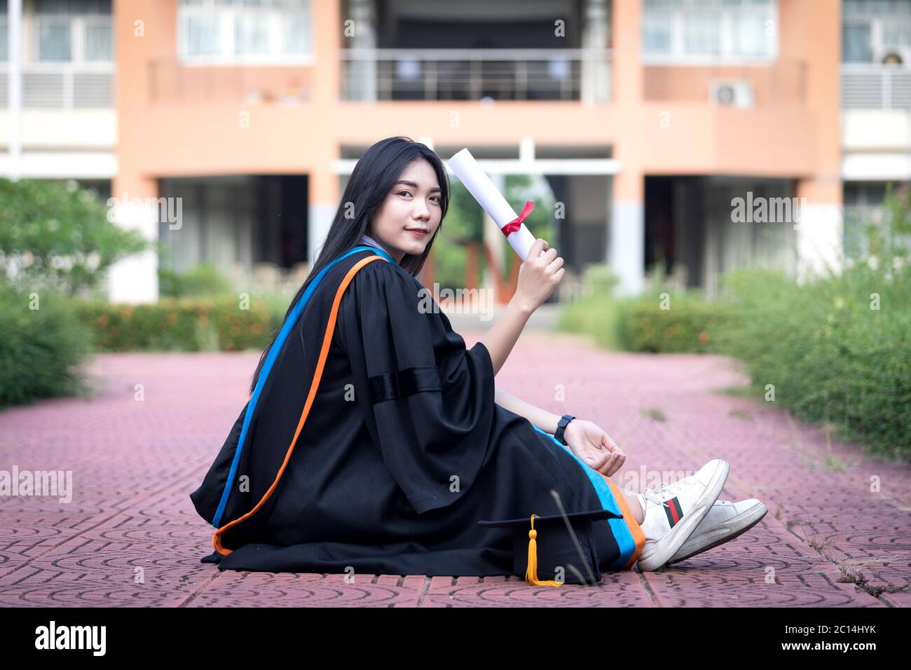 Portrait of happy and excited of young Asian female university graduate ...