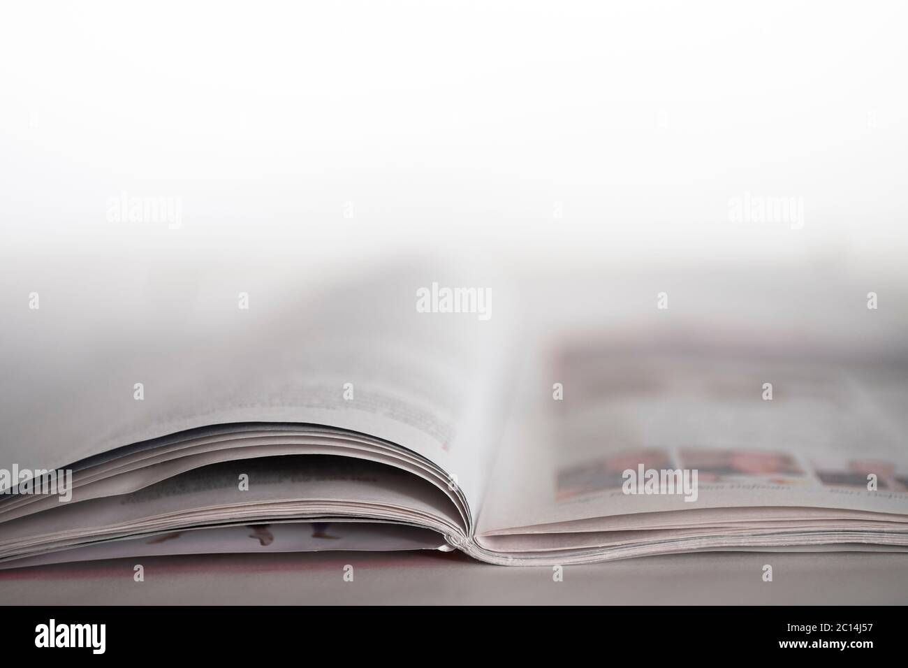 Open magazine on a table with narrow depth of field Stock Photo - Alamy