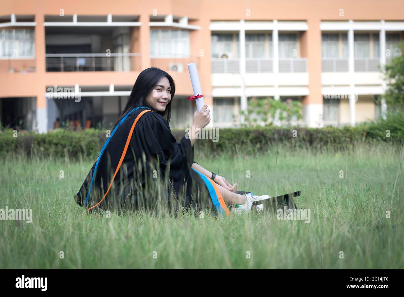 Portrait of happy and excited of young Asian female university graduate ...
