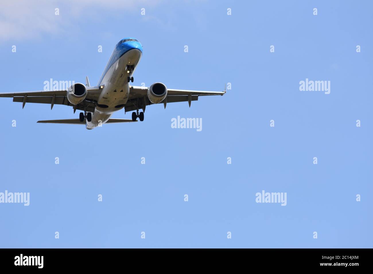 A blue and white aeroplane in the sky Stock Photo - Alamy