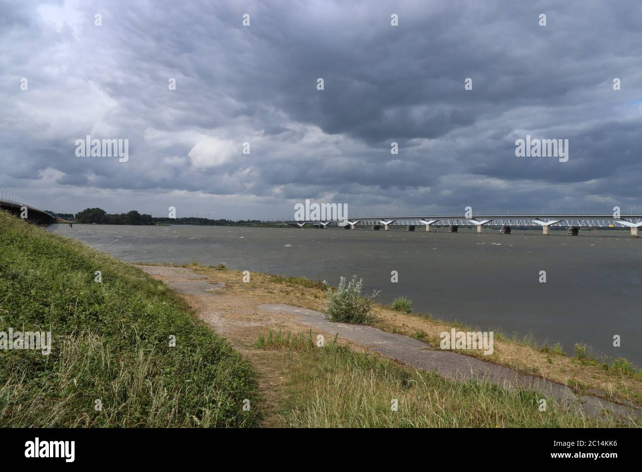 Dark clouds above Hollands Diep water with train bridges over it named ...