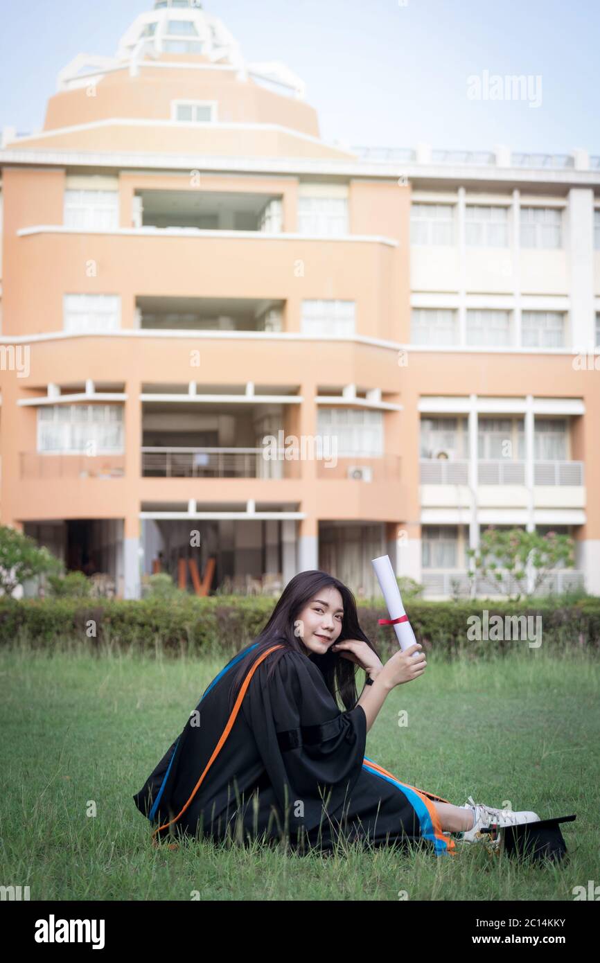 Portrait of happy and excited of young Asian female university graduate ...