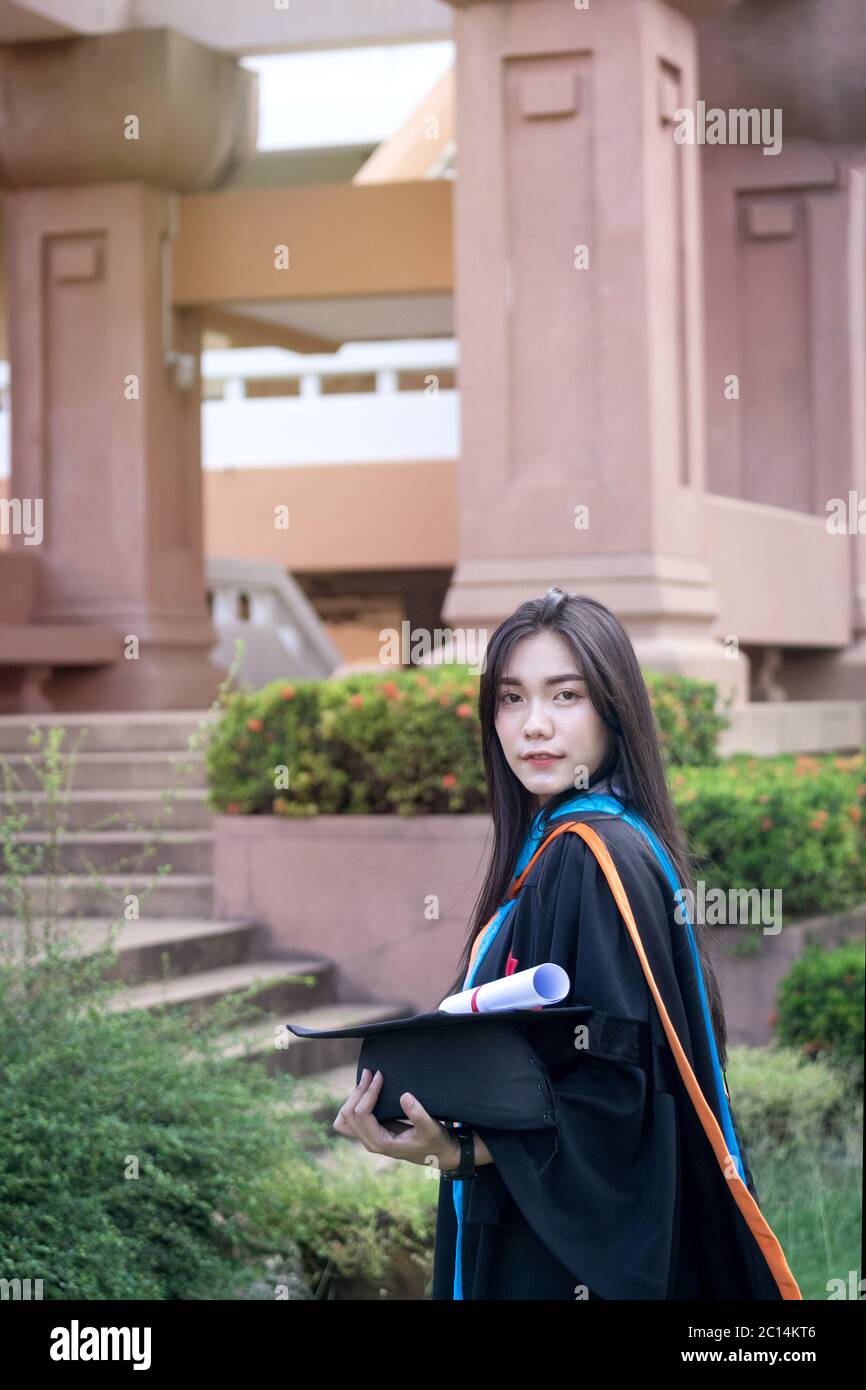 Portrait of happy and excited of young Asian female university graduate ...