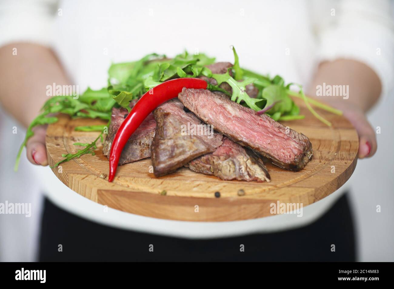 Sliced medium rare grilled Beef steak Ribeye in hands of a woman Stock ...