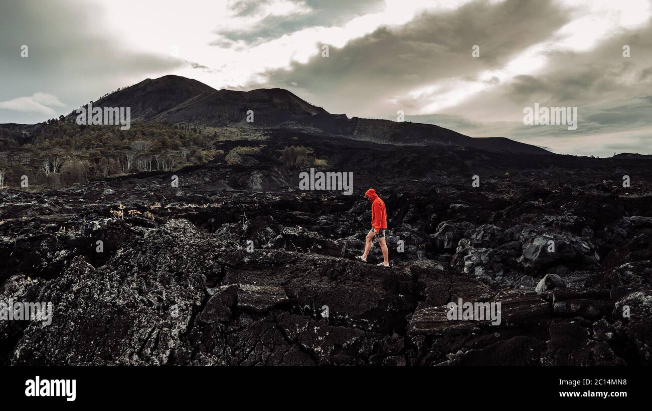 Man tourist with red jacket look the mount Batur on the island of Bali ...