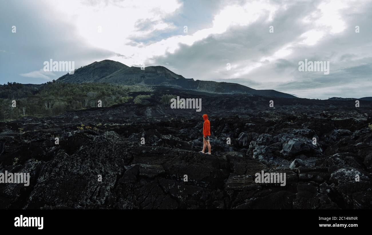 Man tourist with red jacket look the mount Batur on the island of Bali ...