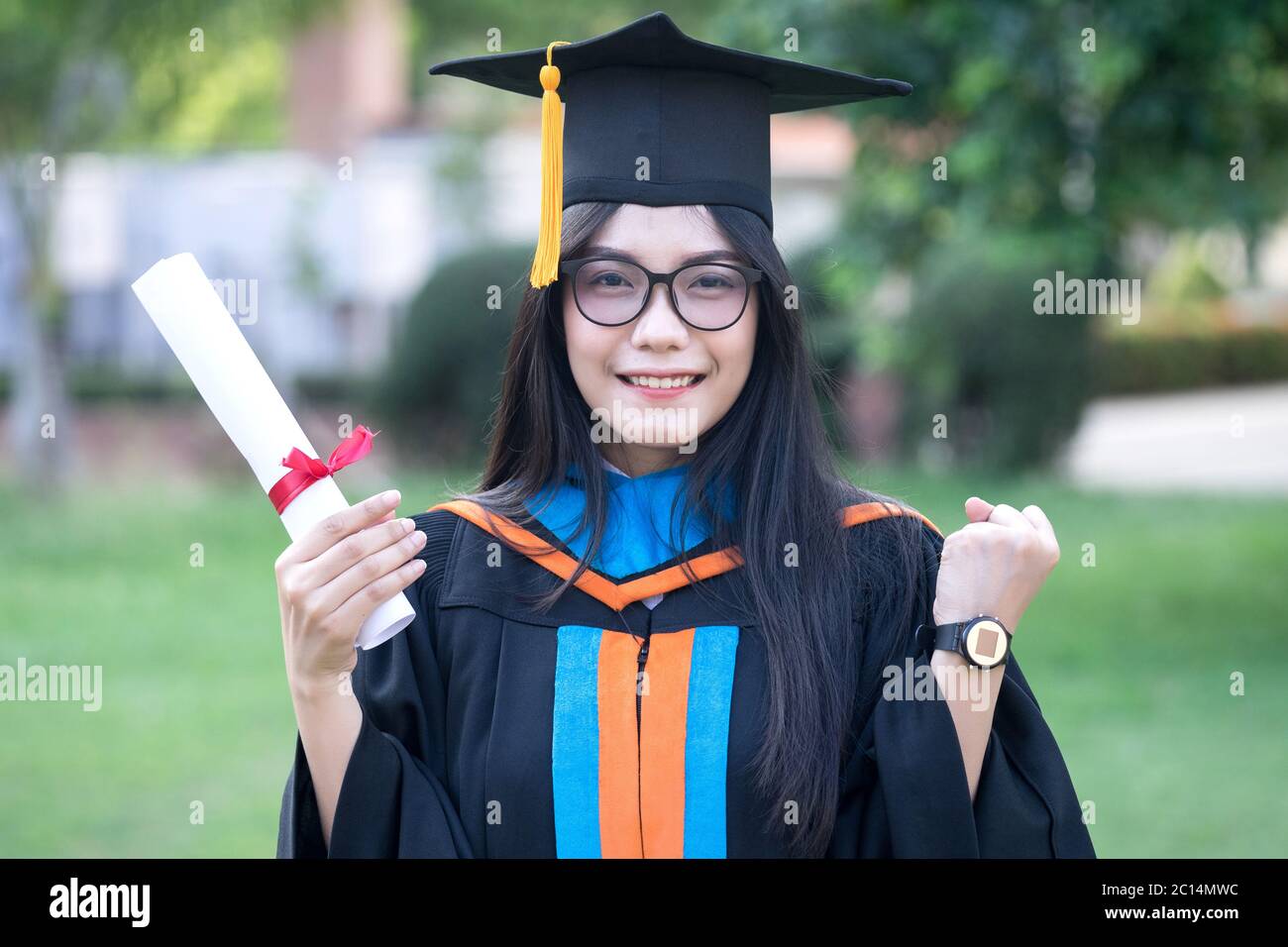 Portrait of happy and excited of young Asian female university graduate ...