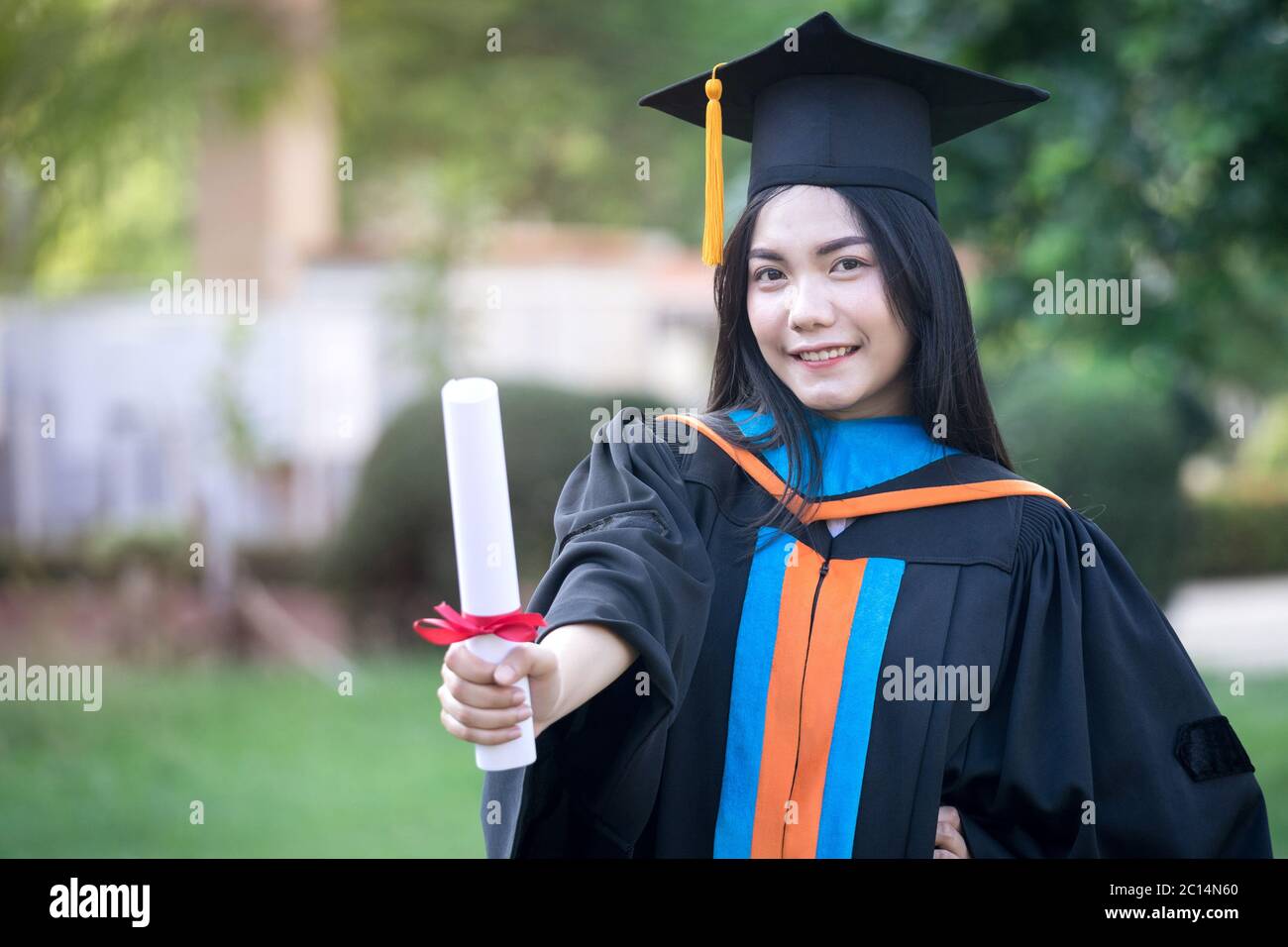 Portrait of happy and excited of young Asian female university graduate ...