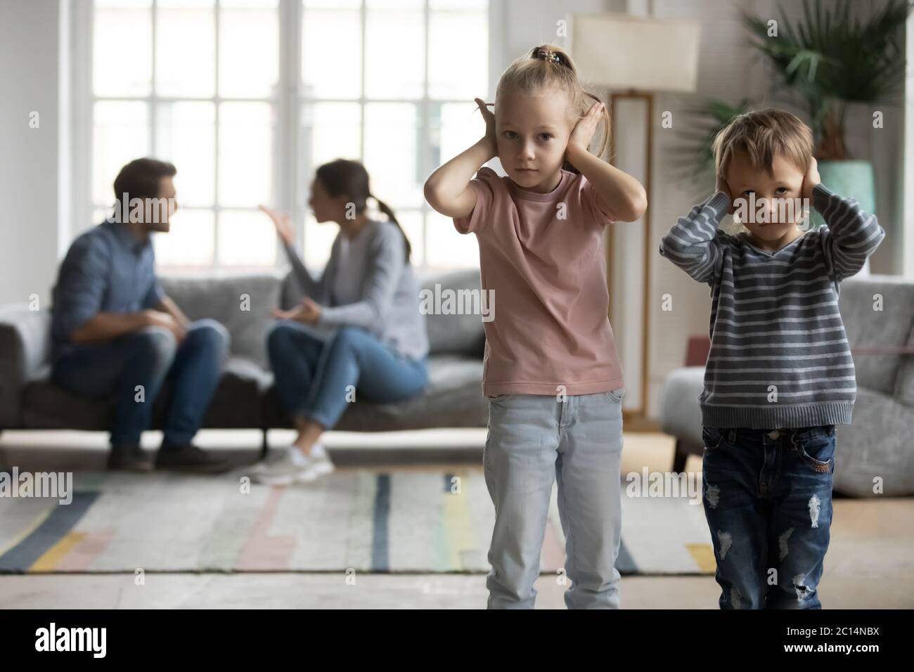 Unhappy little kids covering ears, suffering from parents argument ...