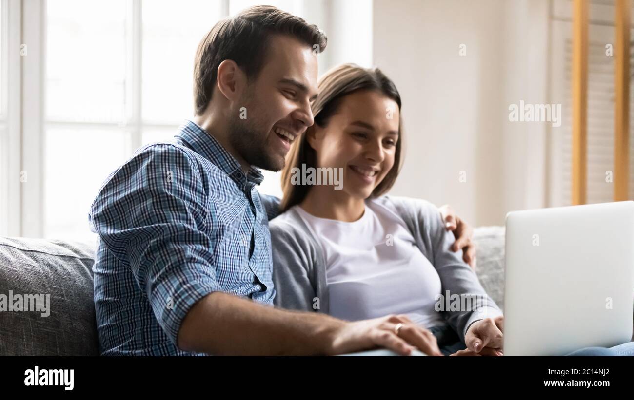 Happy young couple having fun with laptop together Stock Photo - Alamy