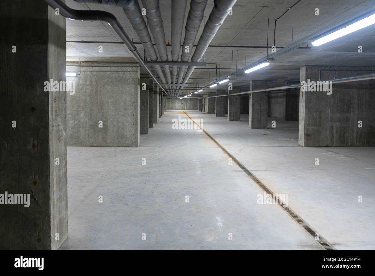 Exposed ceiling pipes in a grey concrete commercial basement in a ...