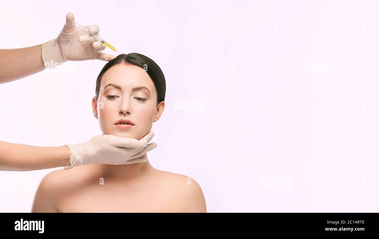 Face needle injection. Young woman cosmetology procedure. Doctor gloves ...