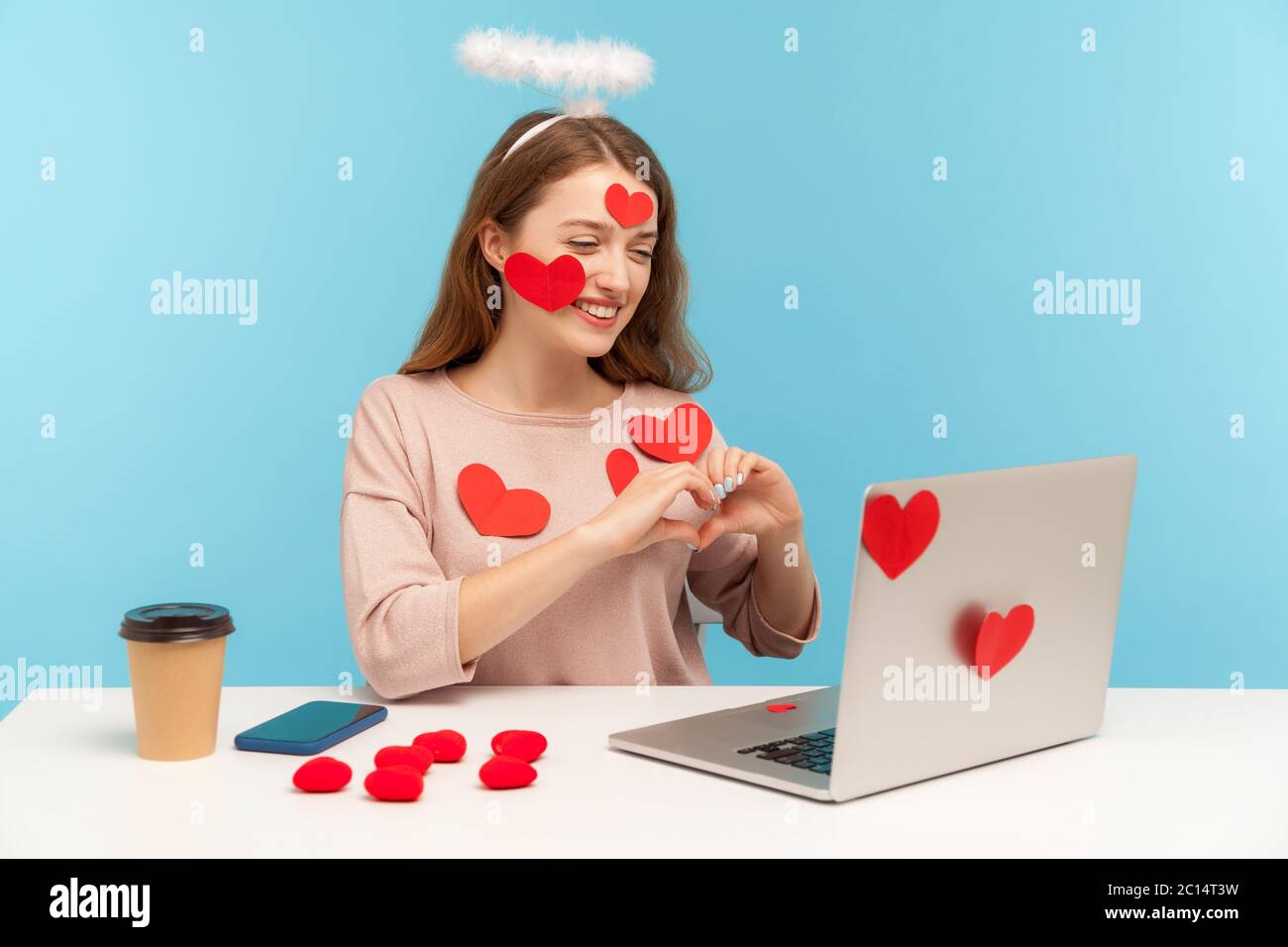 Attractive Angelic Woman With Kind Expression Sitting Covered With Sticker Love Hearts Showing