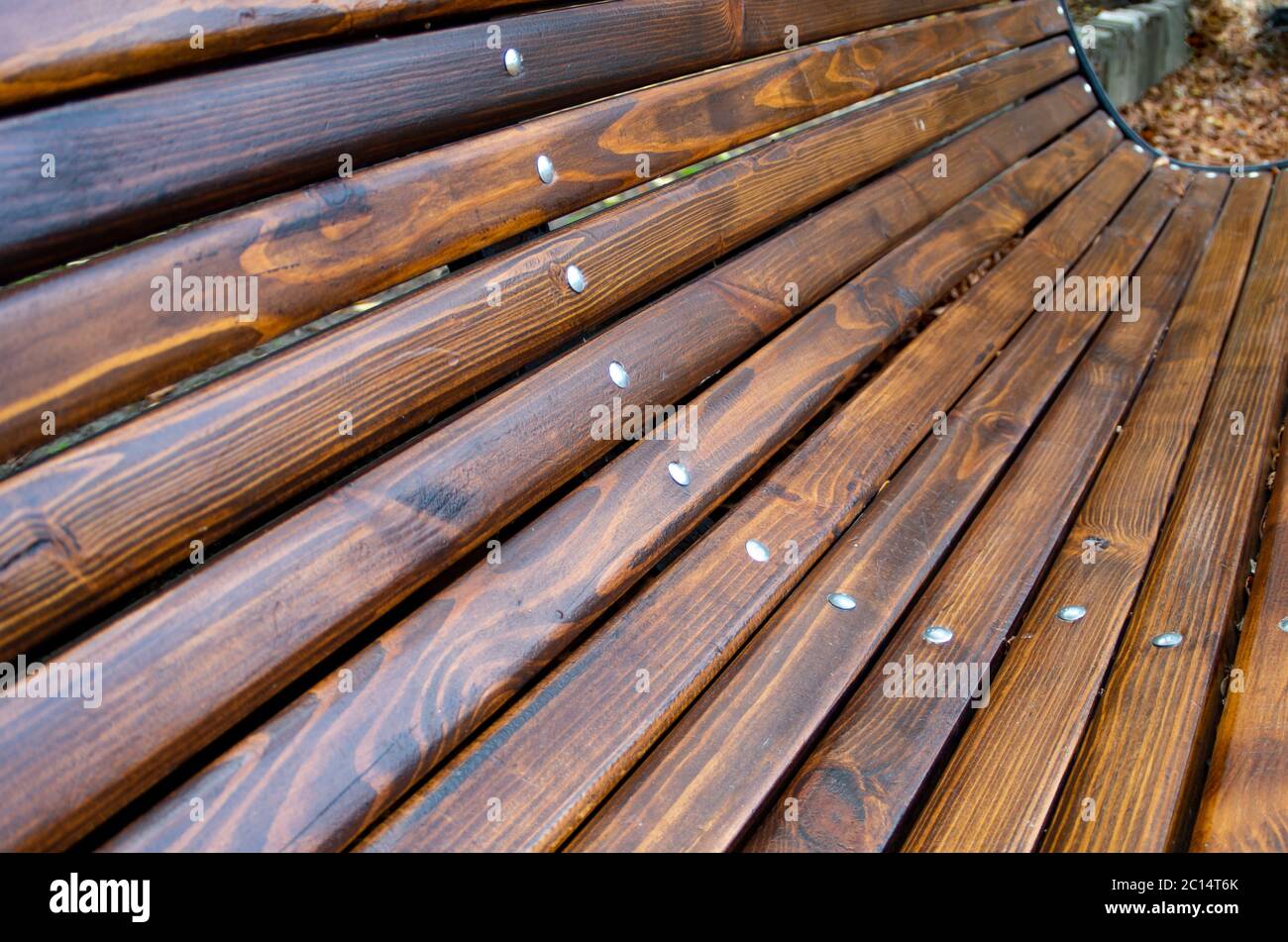 Angled view of a park bench with natural wood texture close up, shallow ...