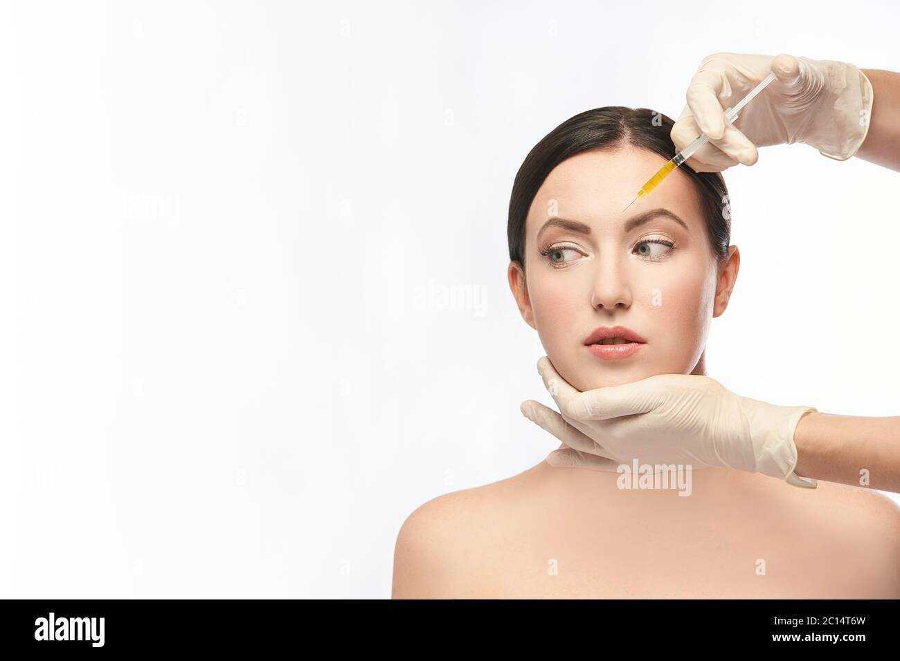 Face needle injection. Young woman cosmetology procedure. Doctor gloves ...