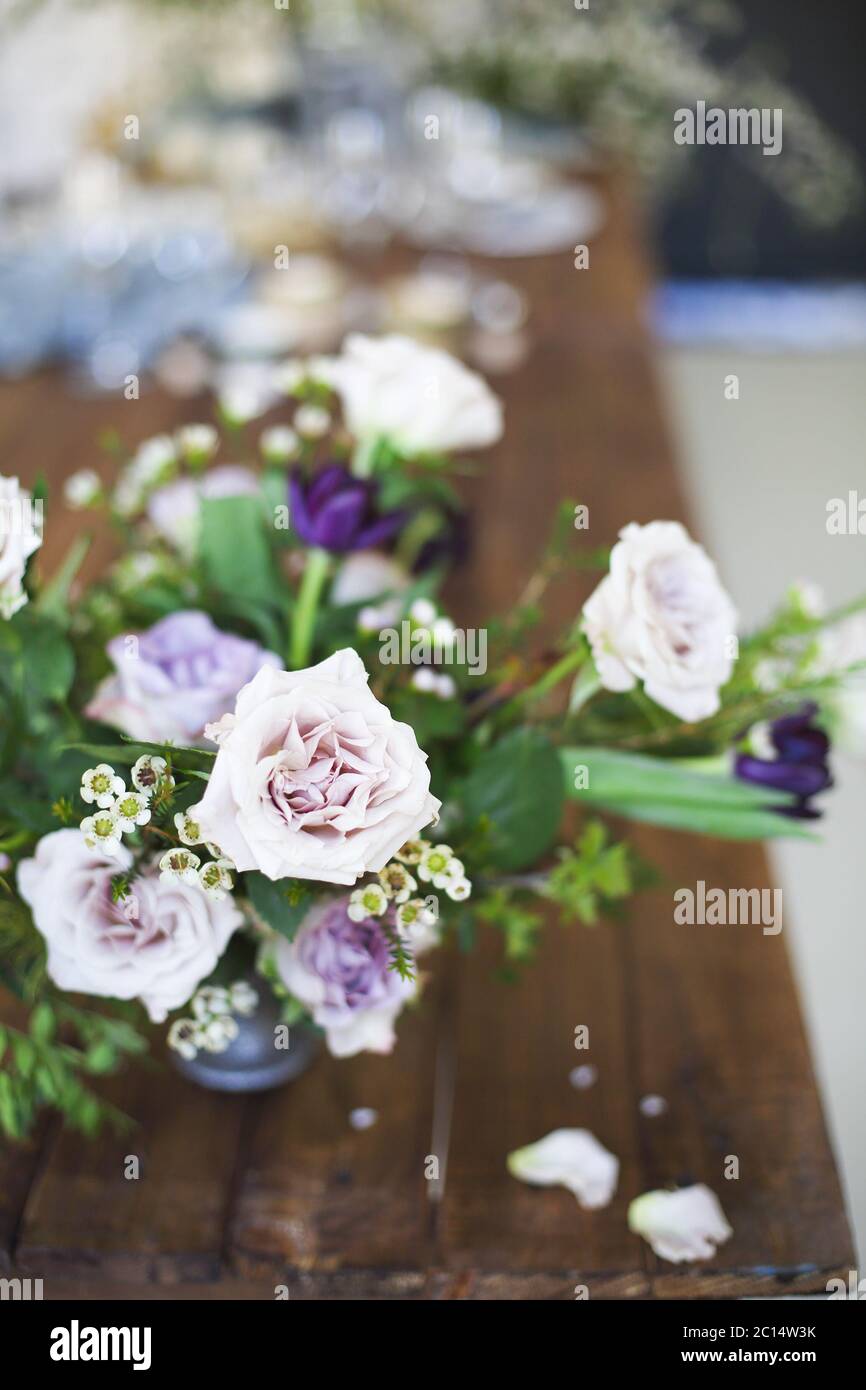 Pink flowers with greenery on white table with space for hi-res stock ...