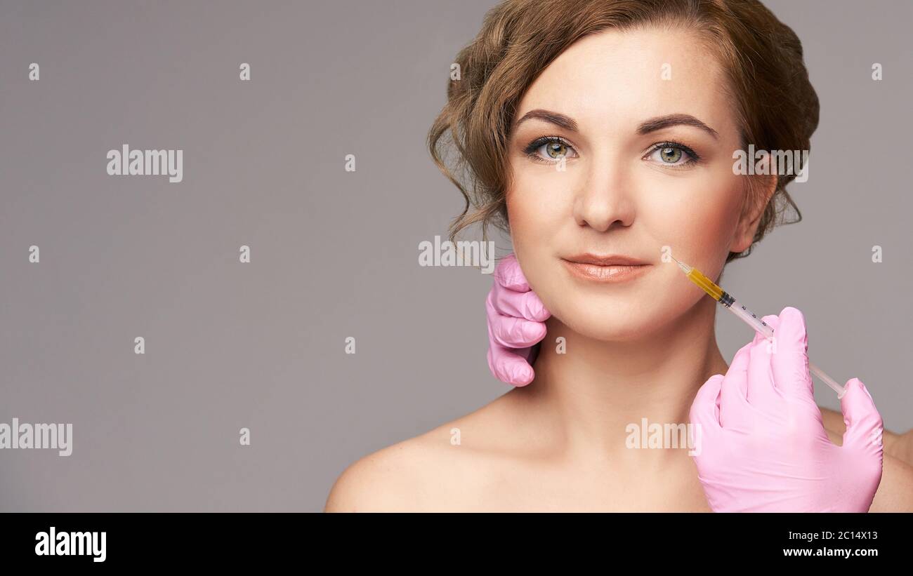 Face needle injection. Young woman cosmetology procedure. Doctor gloves ...
