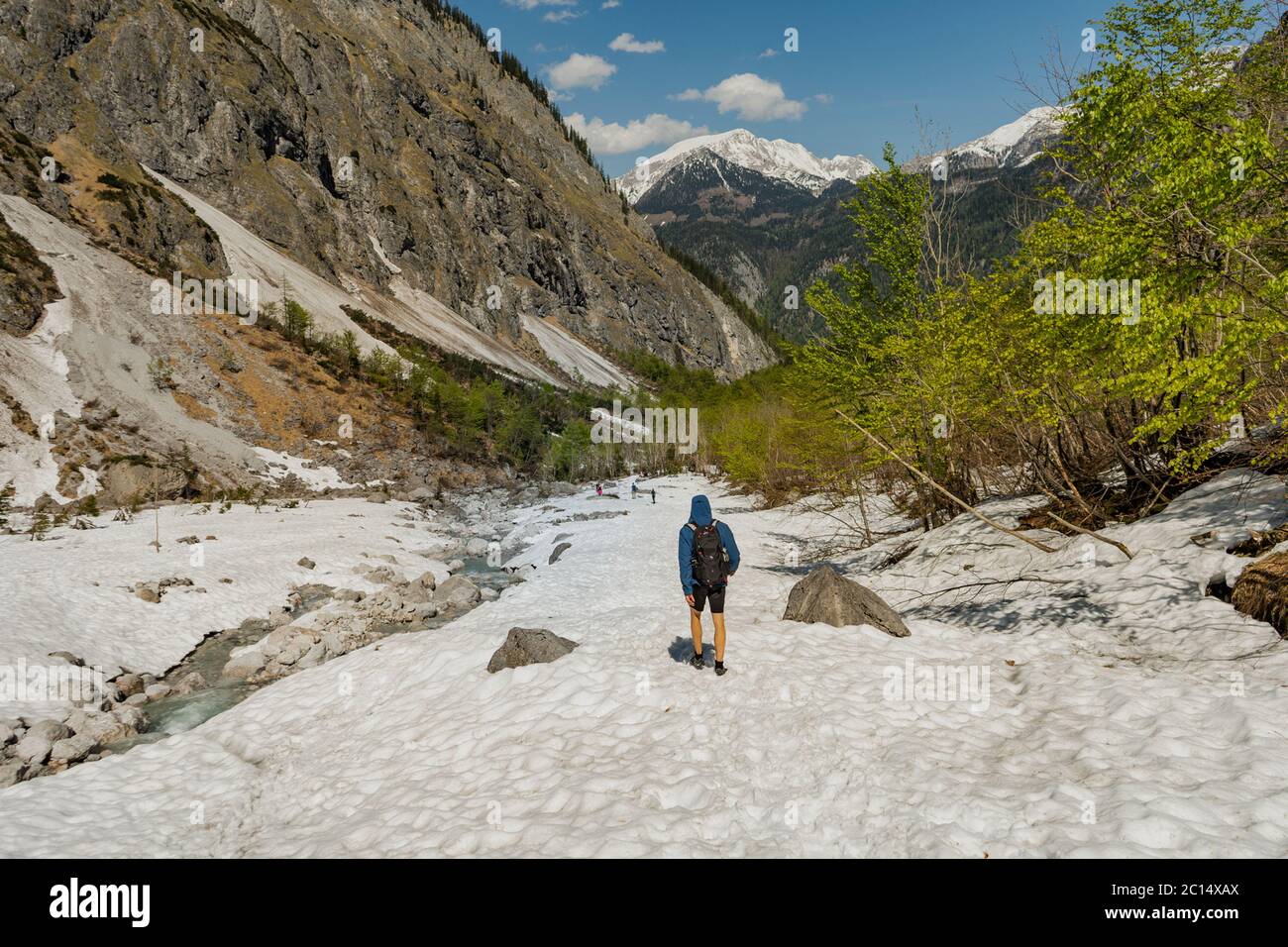 Hiker with backpack of the mountain. Boy walk in fresh snow. Fallen ...