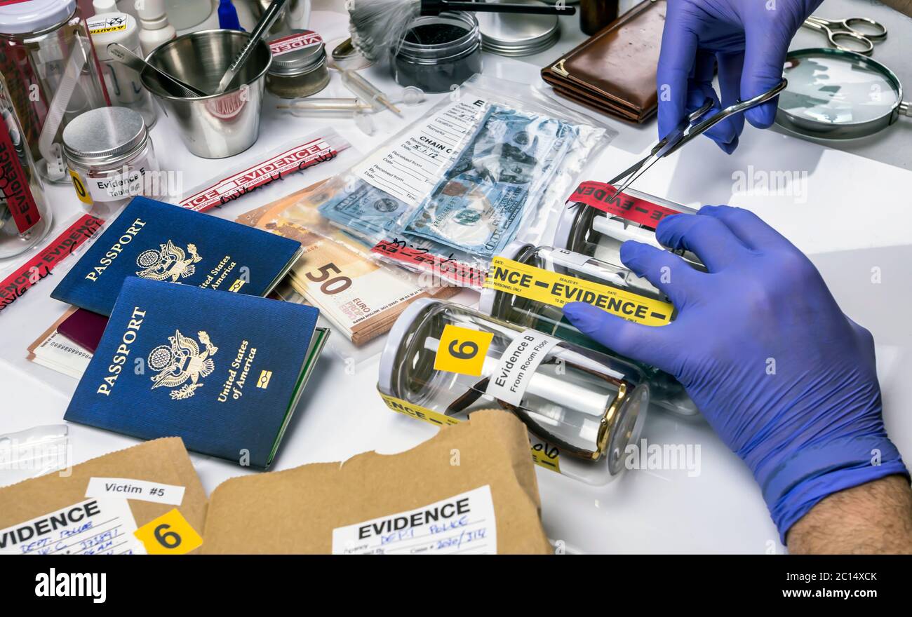 Scientific police opens with scissors a bag of evidence of a crime in ...