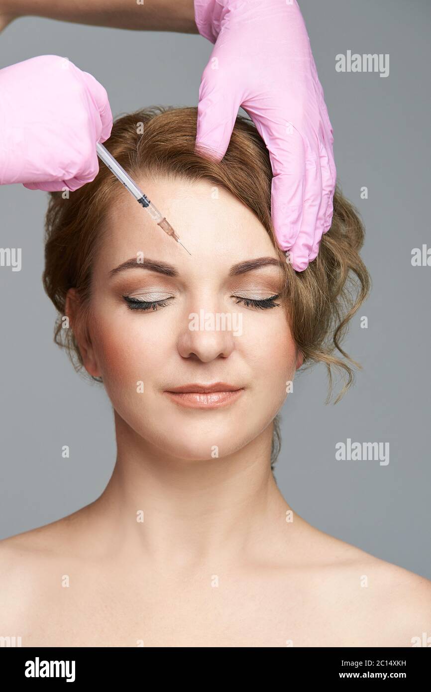 Face needle injection. Young woman cosmetology procedure. Doctor gloves ...