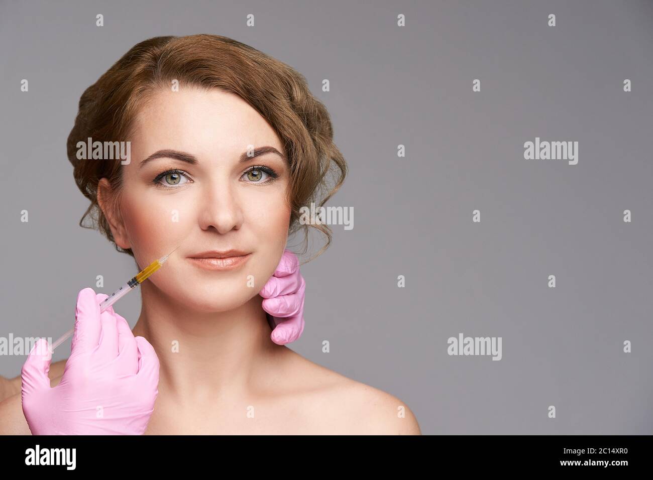 Face needle injection. Young woman cosmetology procedure. Doctor gloves ...