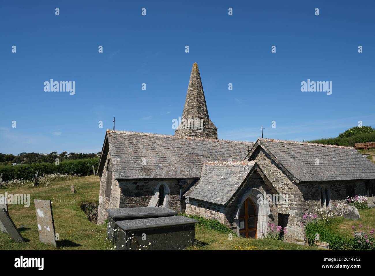 Outside view of St Enodoc Church at Cornwall against a clear blue sky ...