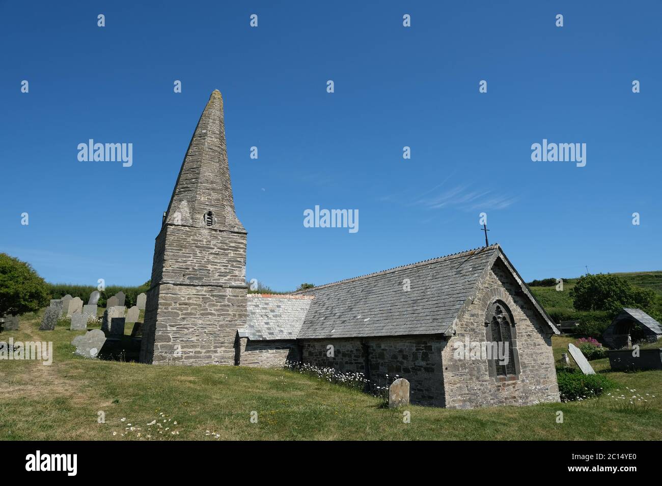 Outside view of St Enodoc Church at Cornwall against a clear blue sky ...