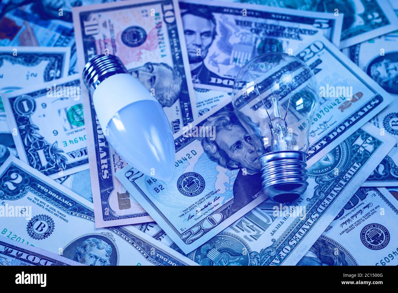 LED lamp and bulb on dollar bills background. The concept of saving ...