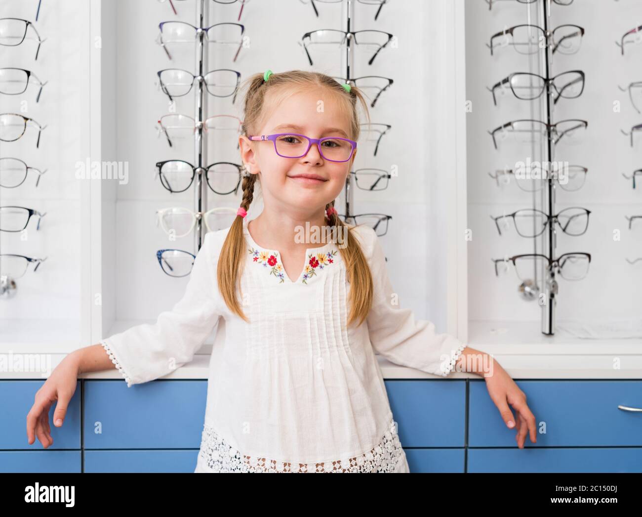 Little girl with a glasses standing in the optical store Stock Photo ...