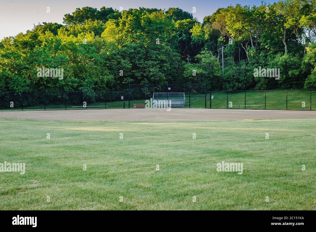 the view from the outfield of a youth baseball field in a city park ...